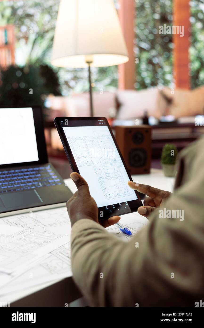 Business owner analyzing blueprints and layouts for a new office space ...