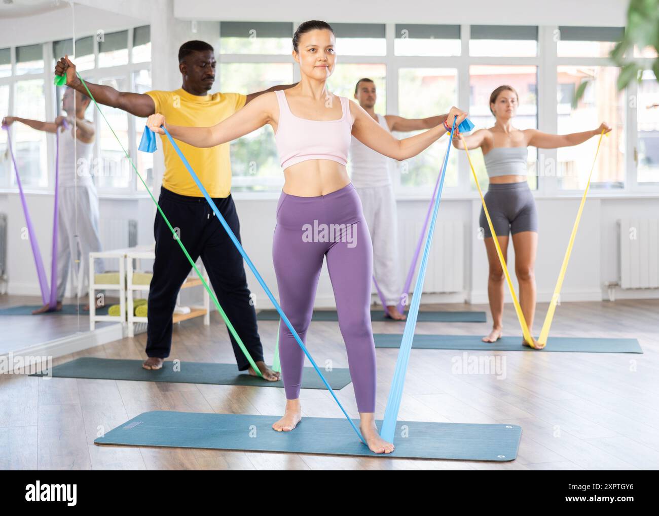 Group of athletes train in Pilates class using elastic bands Stock ...