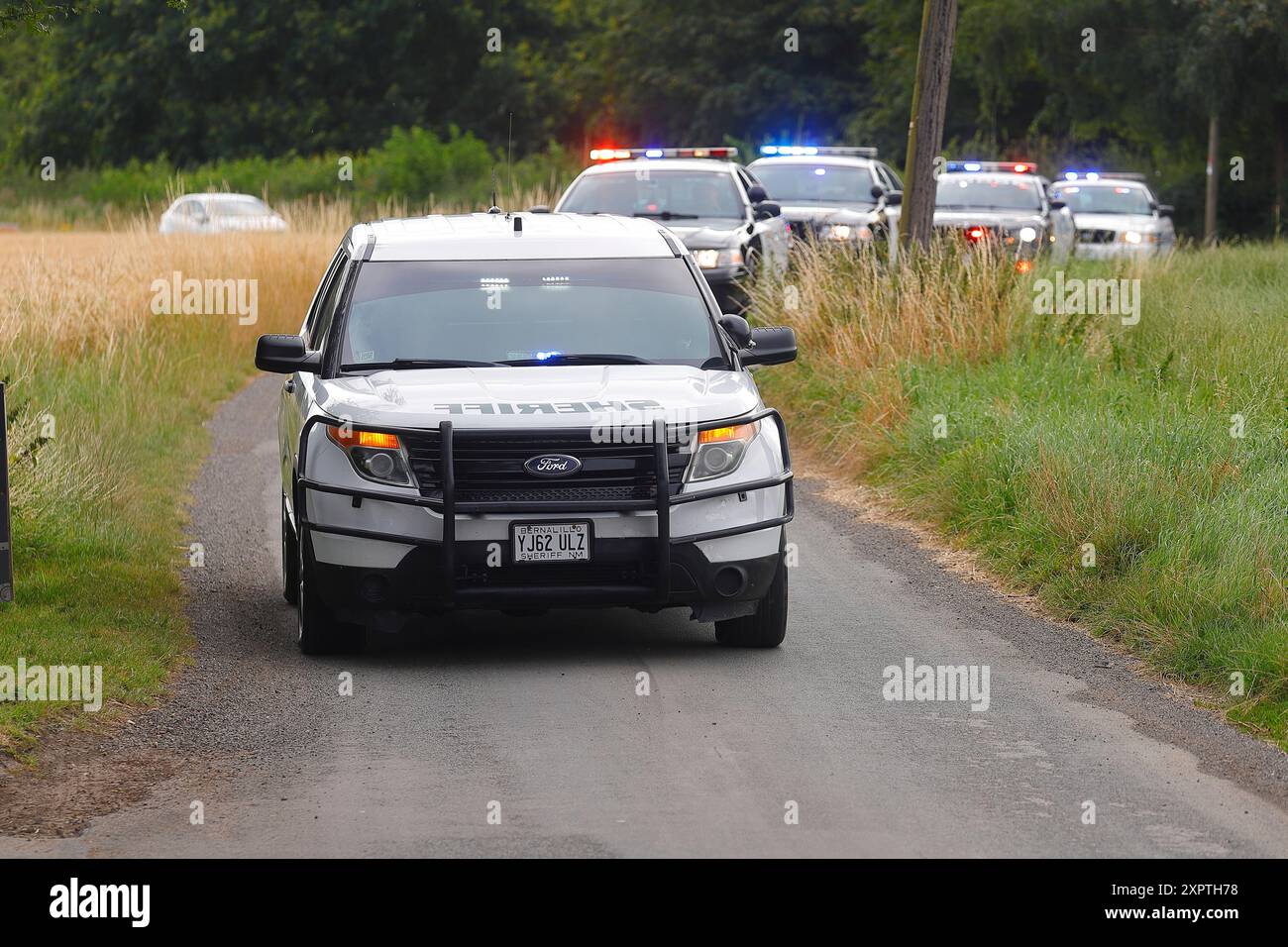 A convoy of American ex cop cars turn up with lights flashing to the ...