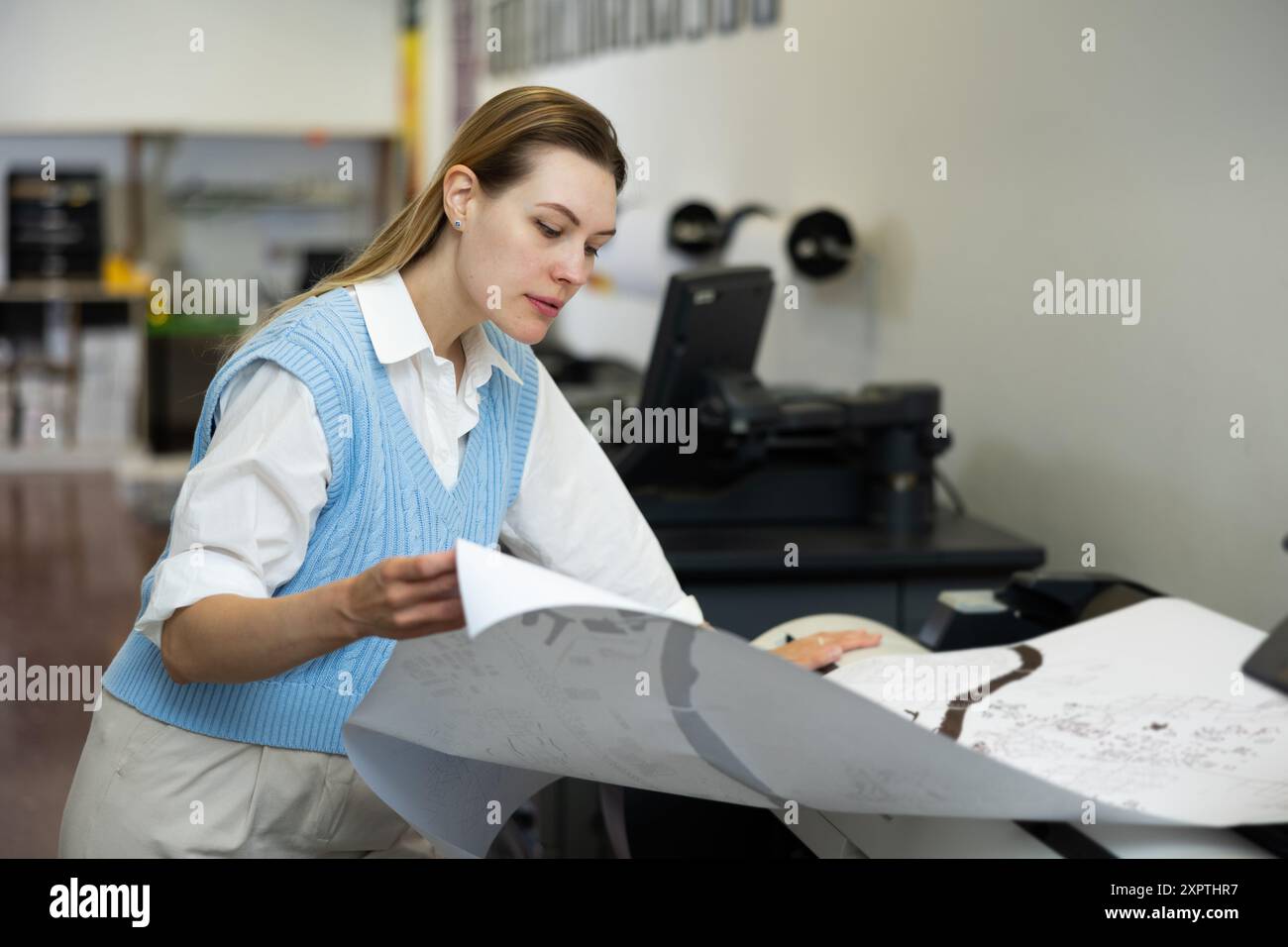 Woman using printer while working in print shop Stock Photo - Alamy