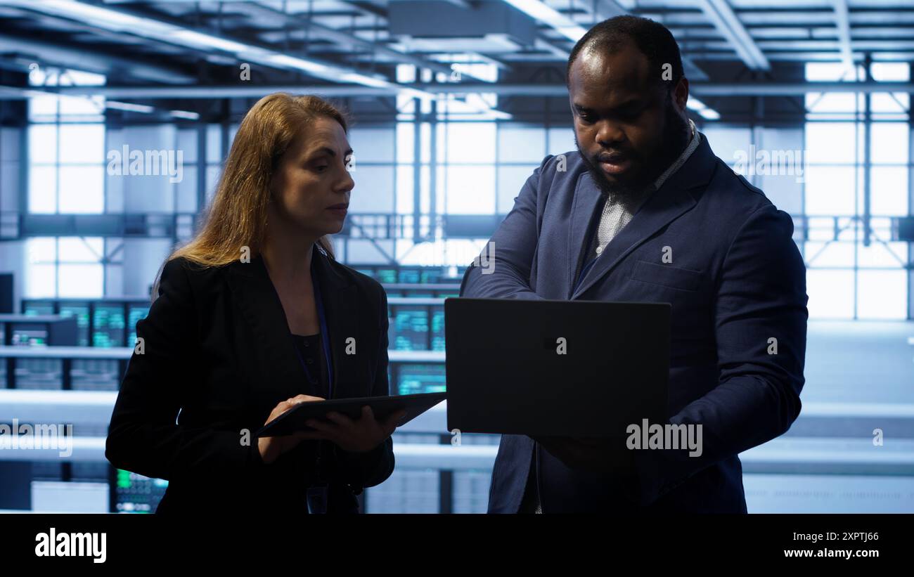 Team of IT specialists managing data center with advanced technology ...