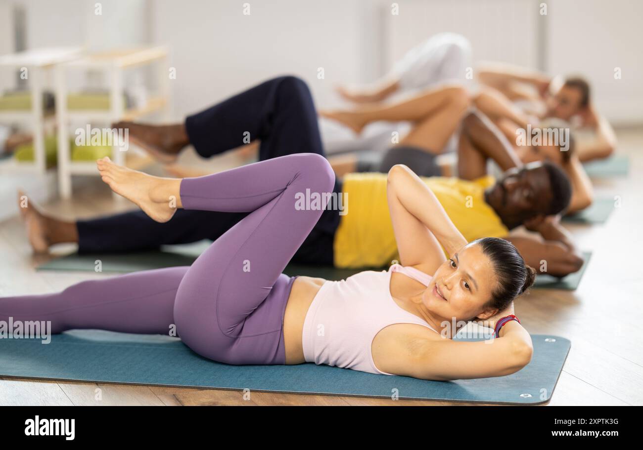 Asian woman performs exercises to strengthen abdominal muscles during ...