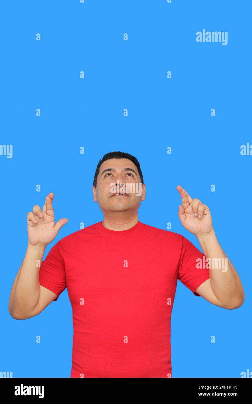 40-year-old dark-skinned Latino man crosses his fingers as a sign of ...