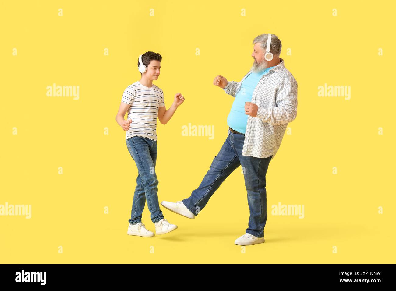 Happy grandfather with his cute grandson in headphones listening music ...