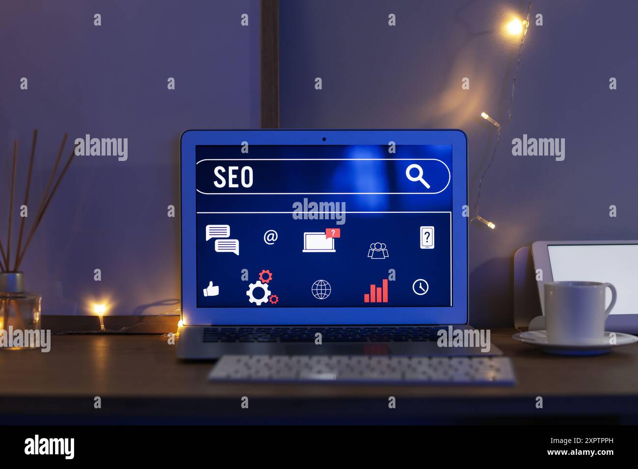 Laptop with abbreviation SEO and search bar on desk in dark office ...