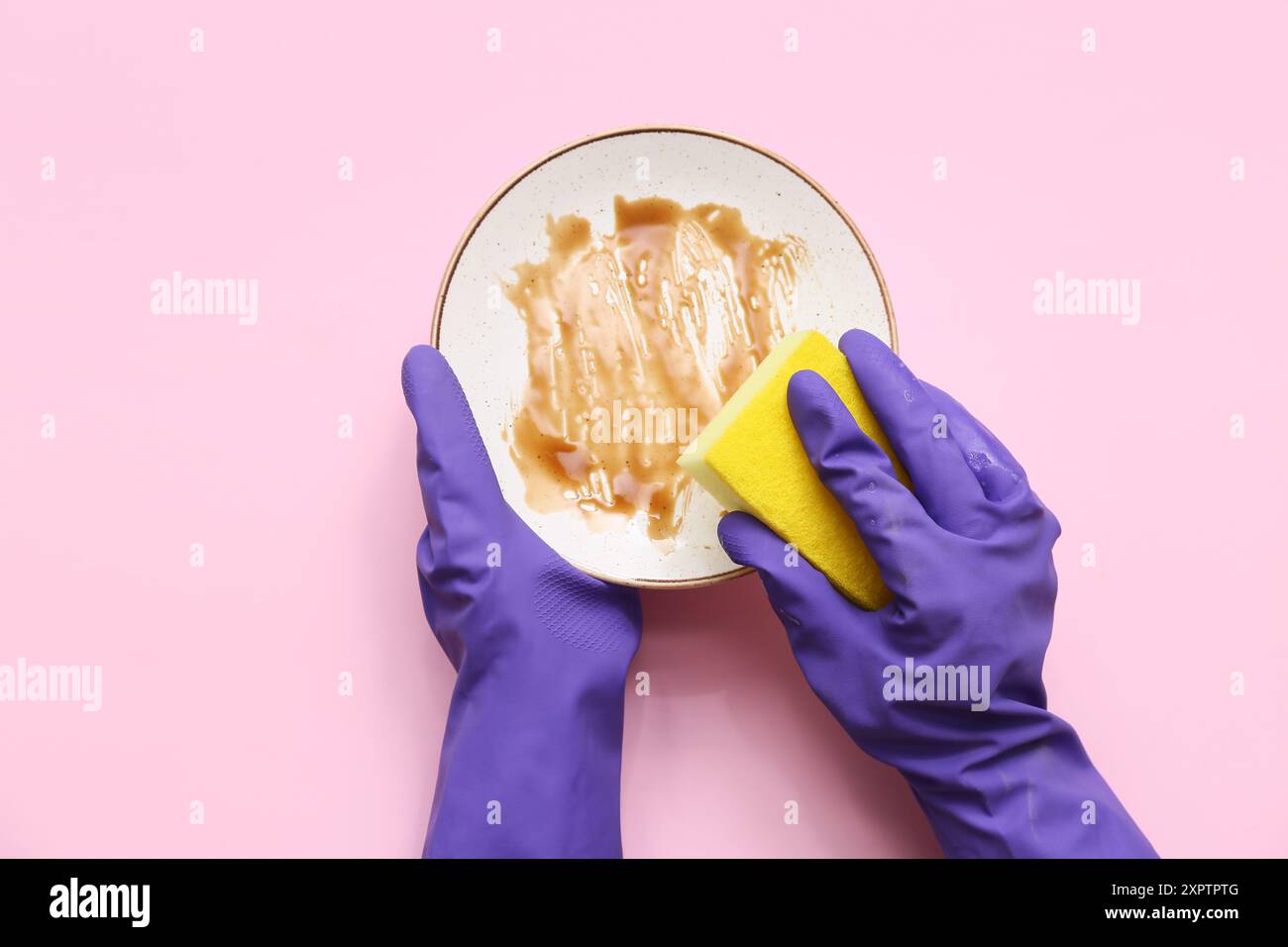 Hands washing dishes on pink background Stock Photo - Alamy