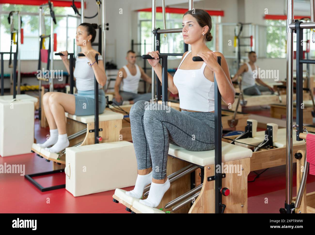 Young girl training her legs in seated position on combo chair Stock ...