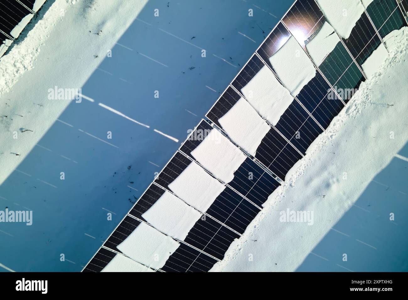 Aerial view of snow melting from covered solar photovoltaic panels at ...