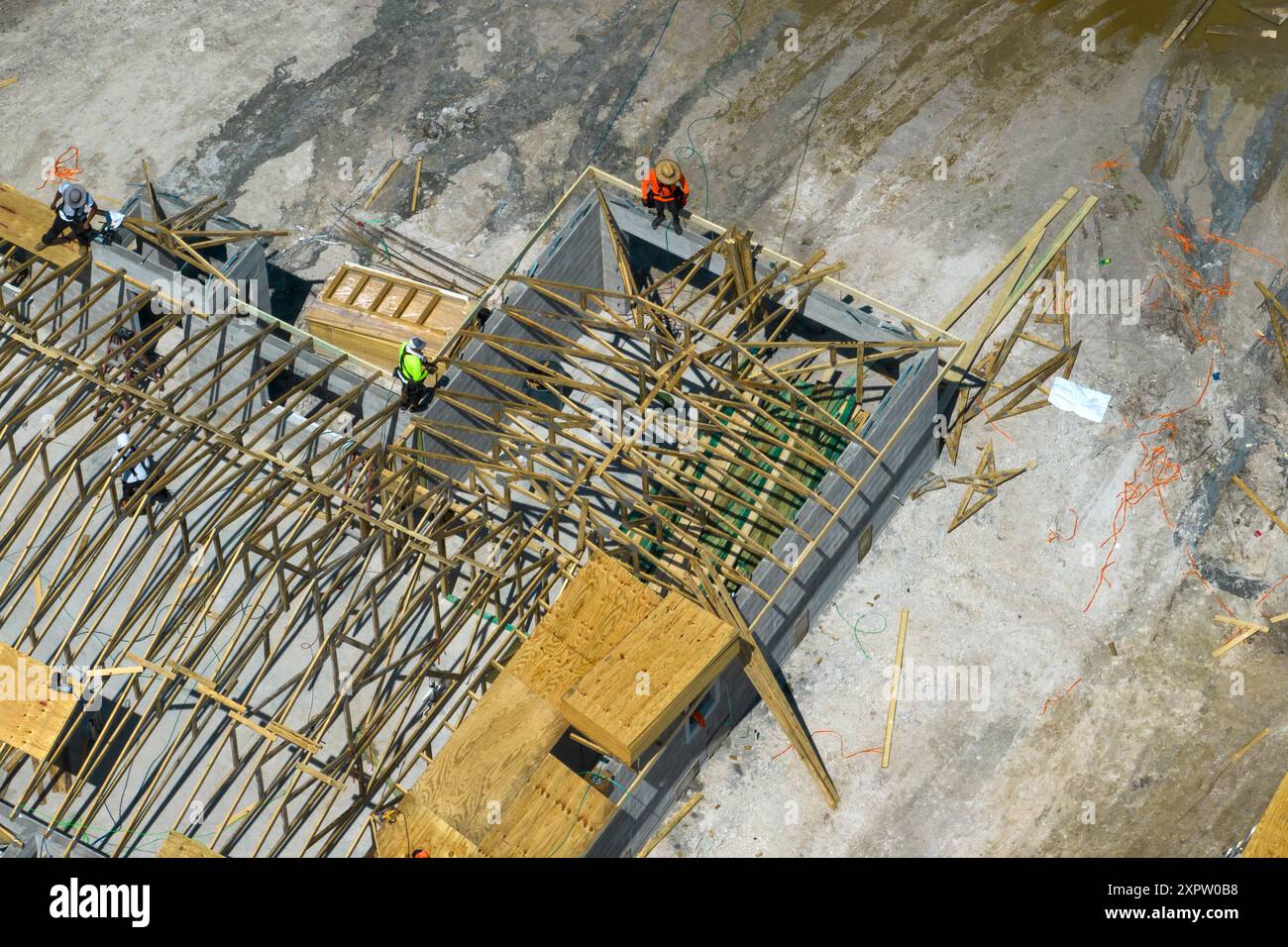 Builders working on roof construction of unfinished residential house ...