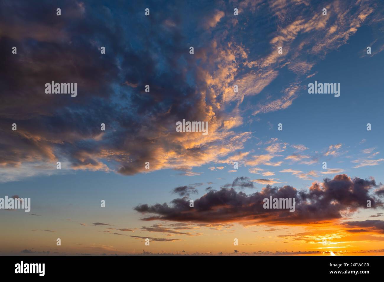 Colorful sunset sky with setting sun behind vivid orange and yellow ...