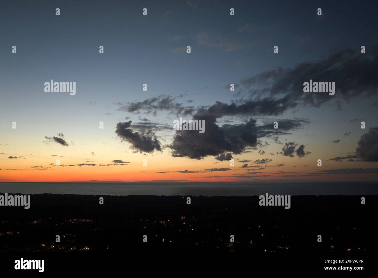 Dramatic sunset sky covered with colorful yellow clouds over dark ...