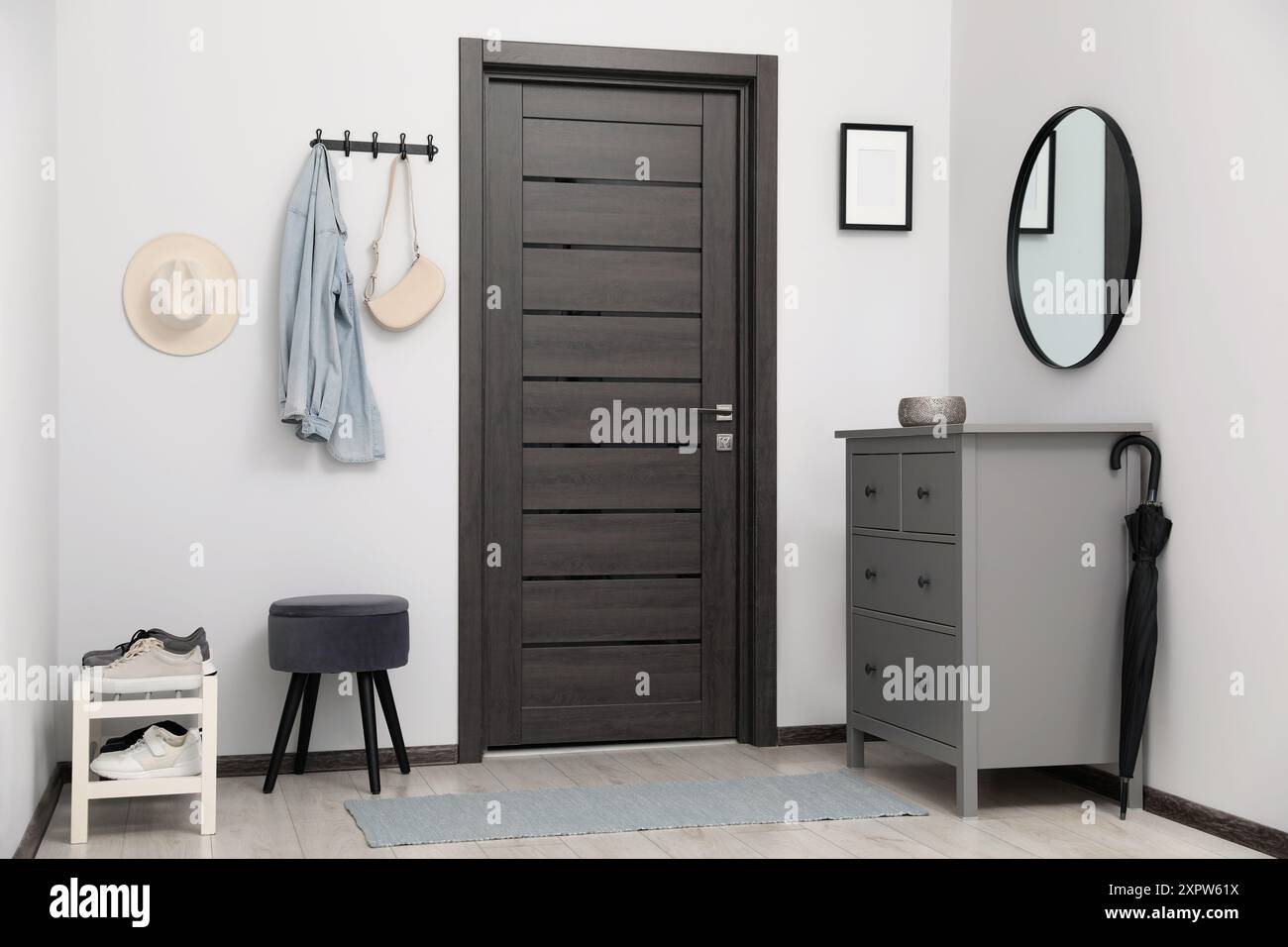 Chest of drawers, mirror and shoe storage bench in hallway. Interior ...