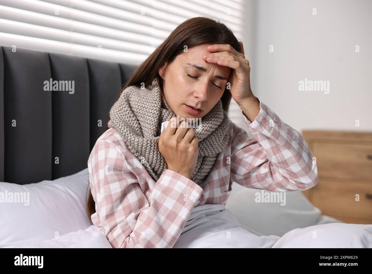 Sick woman with tissue in bed. Cold symptoms Stock Photo - Alamy