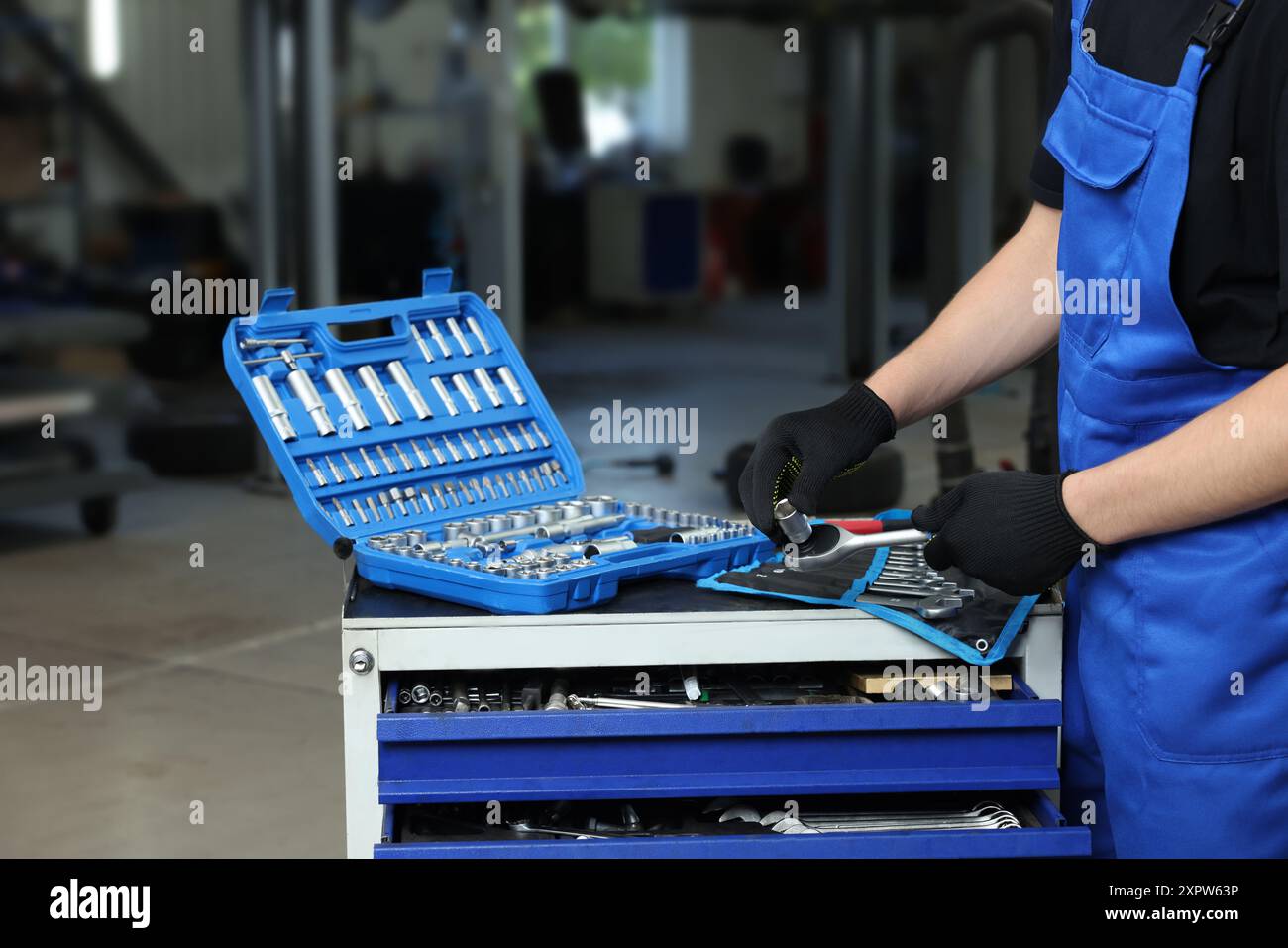 Auto mechanic with different tools at automobile repair shop, closeup ...