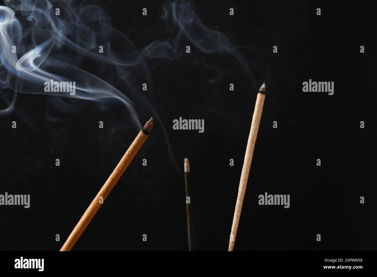 Aromatic incense sticks smoldering on black background Stock Photo - Alamy