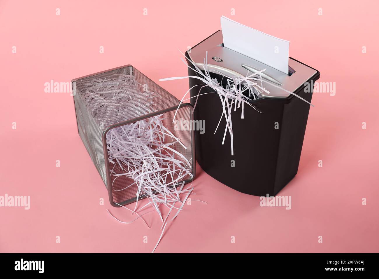 Shredder, metal basket and paper strips on pink background Stock Photo ...