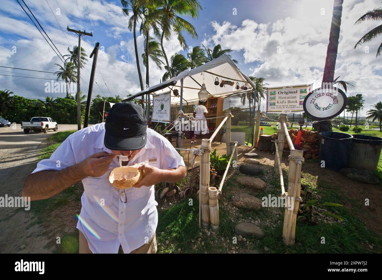 Tourist eating coconut at a local market on Oahu, Hawaii Stock Photo ...