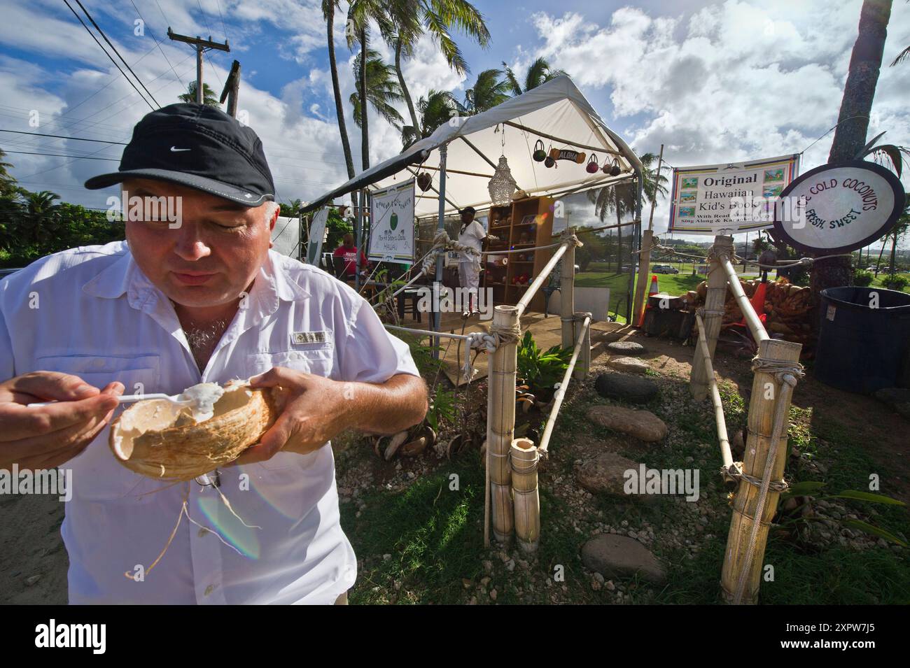 Tourist eating coconut at a local market on Oahu, Hawaii Stock Photo ...