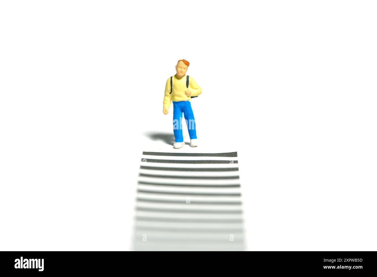 Miniature tiny people toy photography. A boy student waiting on ...