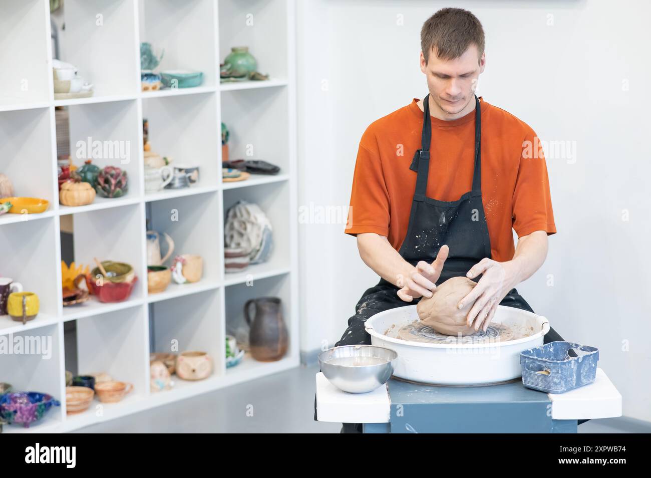 A potter kneads clay before using it on the potter's wheel Stock Photo ...