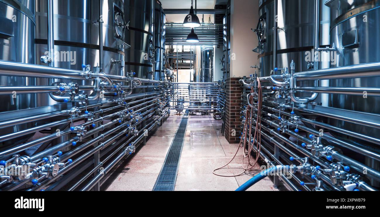 Sleek modern brewery interior with rows of shiny stainless steel tanks ...
