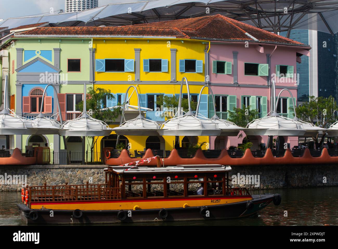An empty bumboat travel on the river, bypass colourful buildings at ...