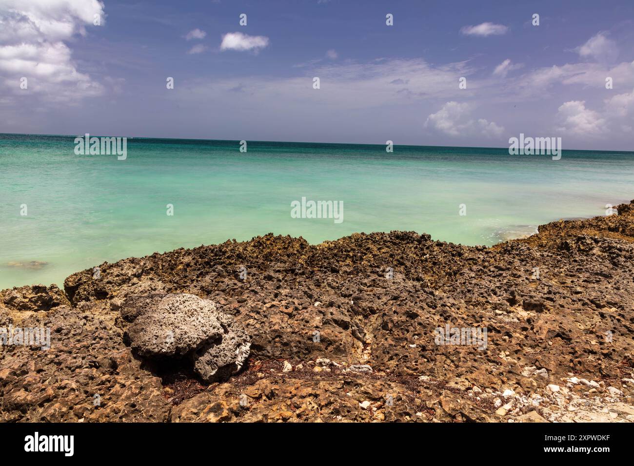 Rocky beach on the island of Aruba. Emerald green water in the bay ...
