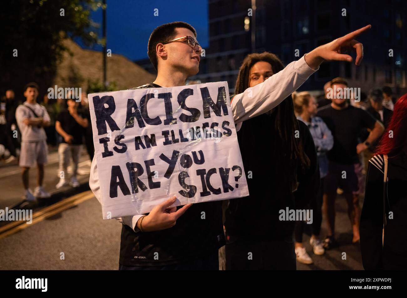 London, UK. 07th Aug, 2024. A counter-protester holds a placard that ...