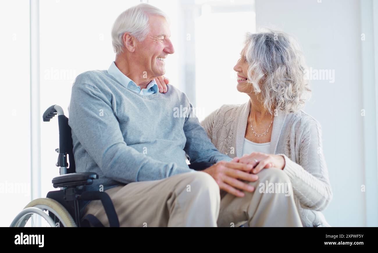 Couple, wheelchair and senior patient in hospital, holding hands and ...