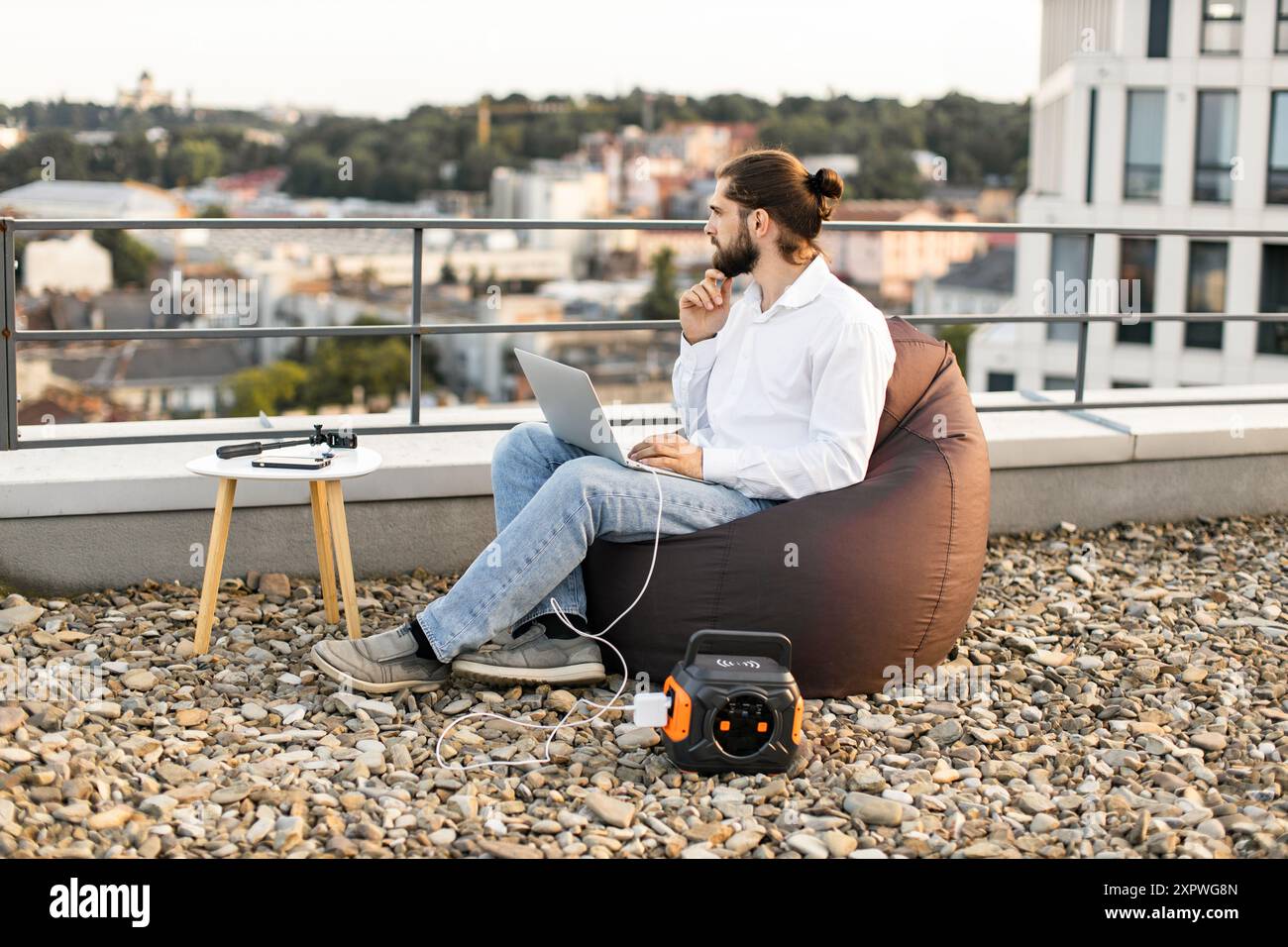 Business man connecting charging cable to portable power station on ...