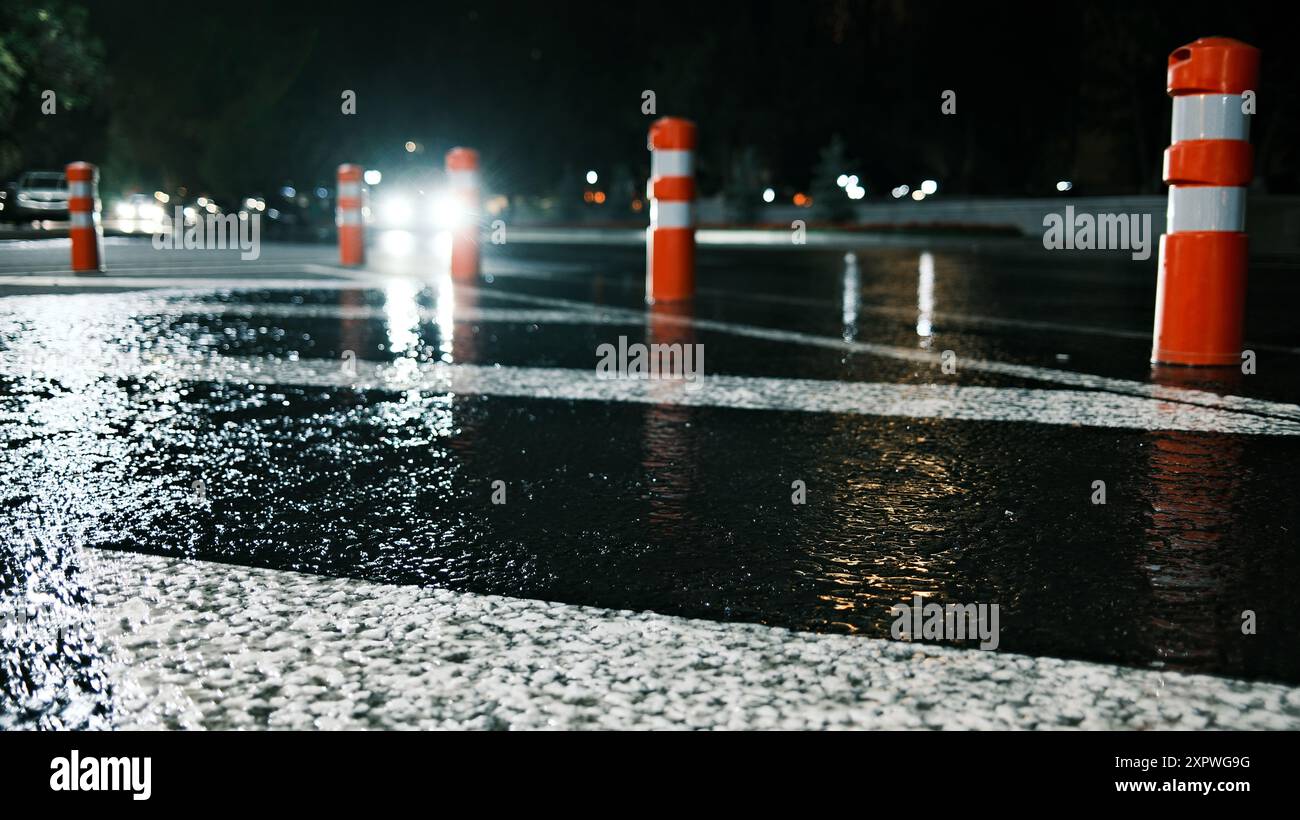 wet black asphalt at night with plastic bollards Stock Photo - Alamy