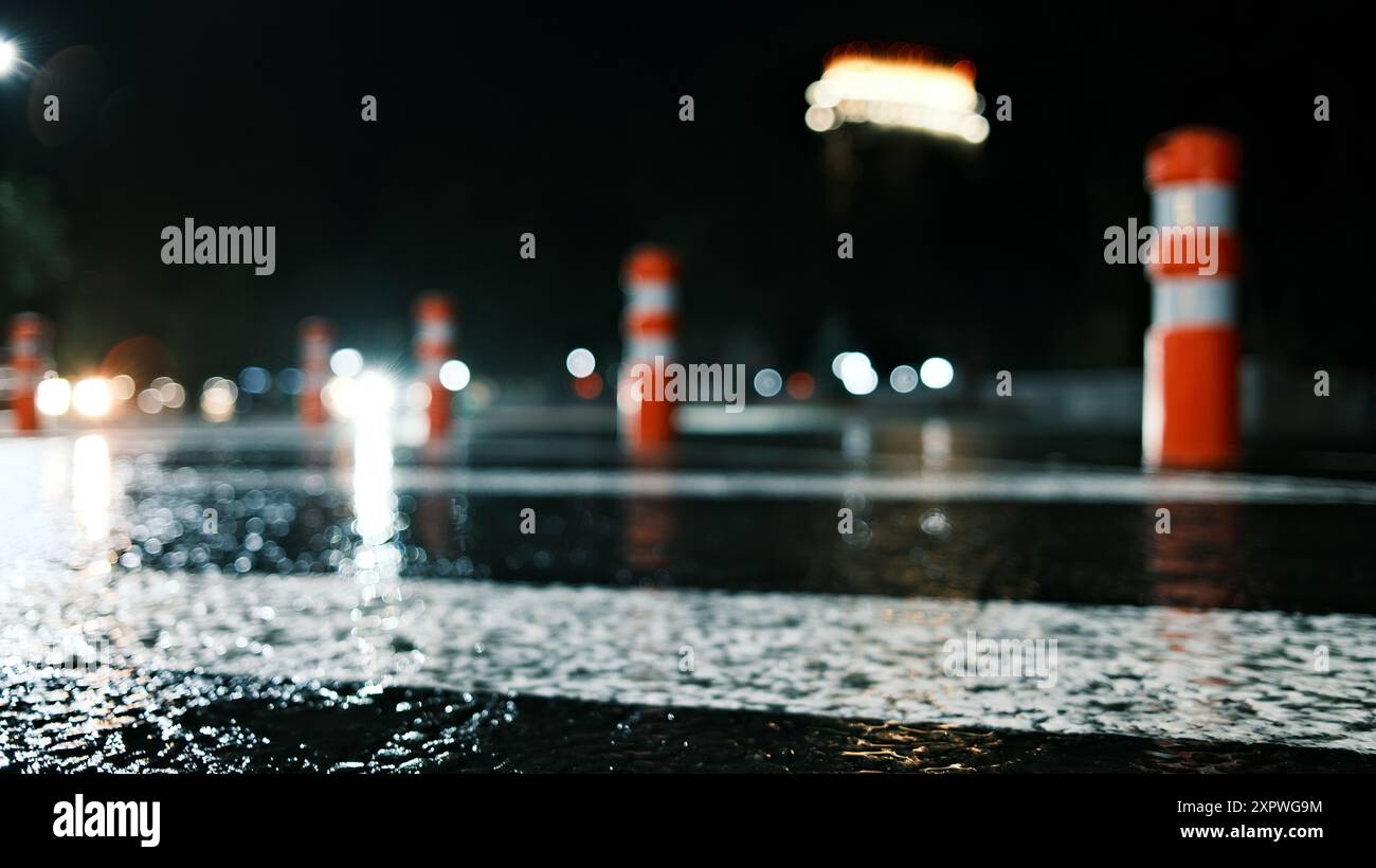 wet black asphalt at night with plastic bollards Stock Photo - Alamy