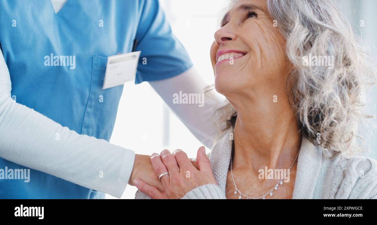 Caregiver, smile and old woman in hospital, holding hands and ...