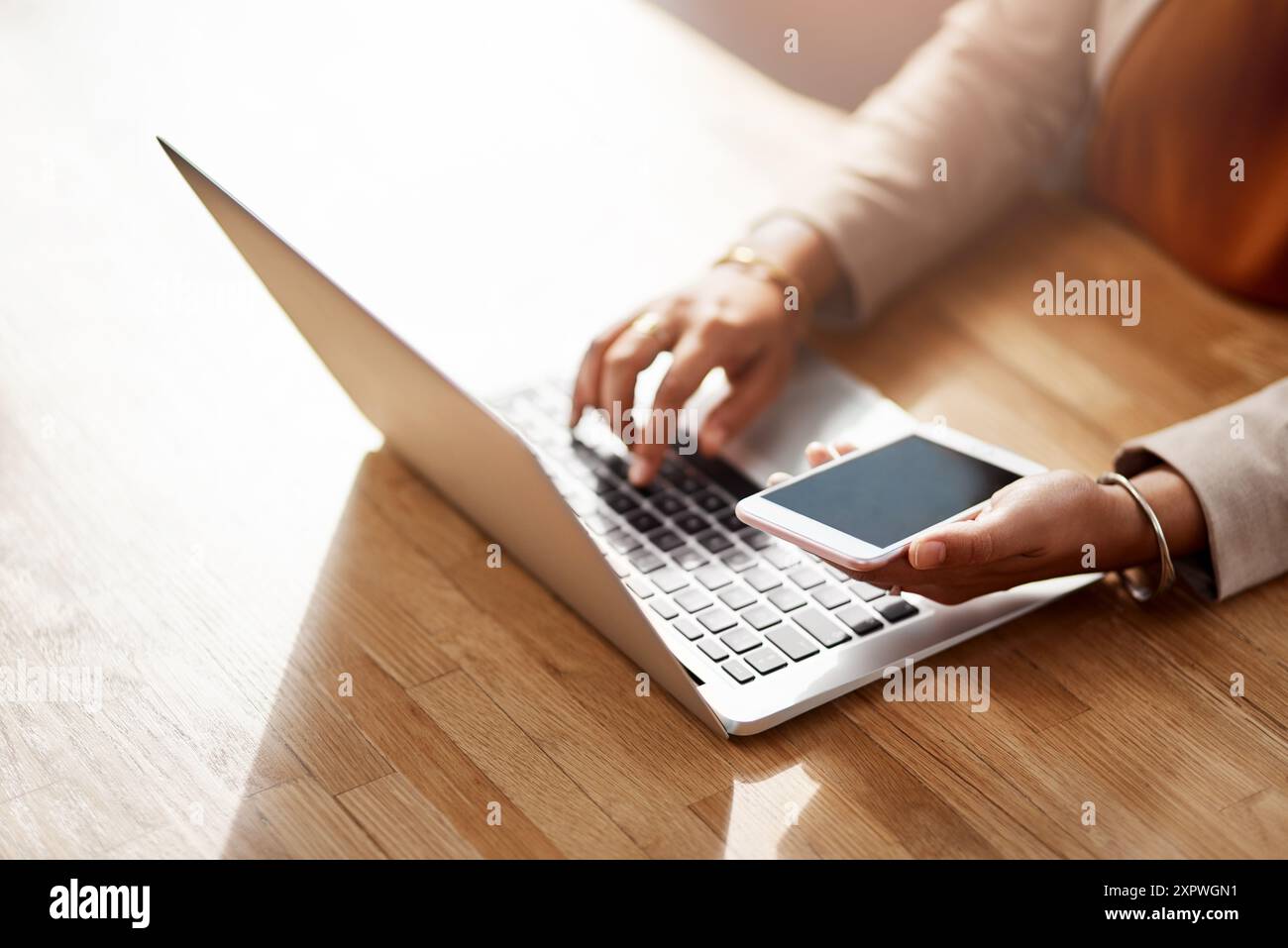 Hands, laptop and phone with person at desk of office for business ...