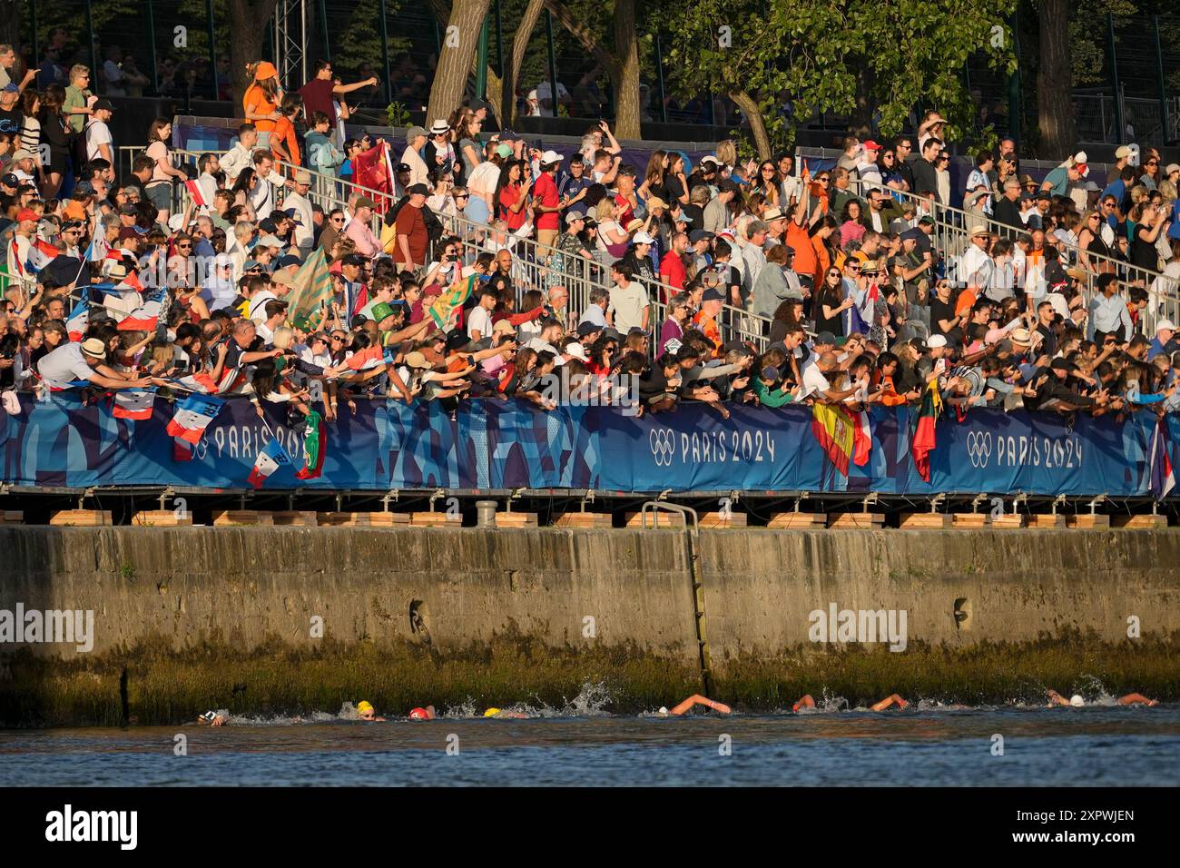 Supporters cheer as athletes swim during the marathon swimming women's ...