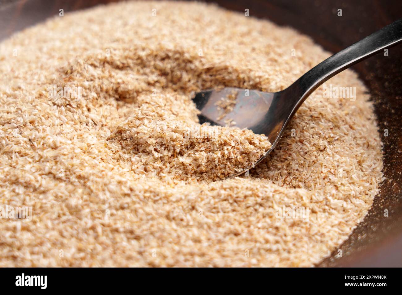 Crude ground psyllium husks in metallic spoon close up. Organic ...