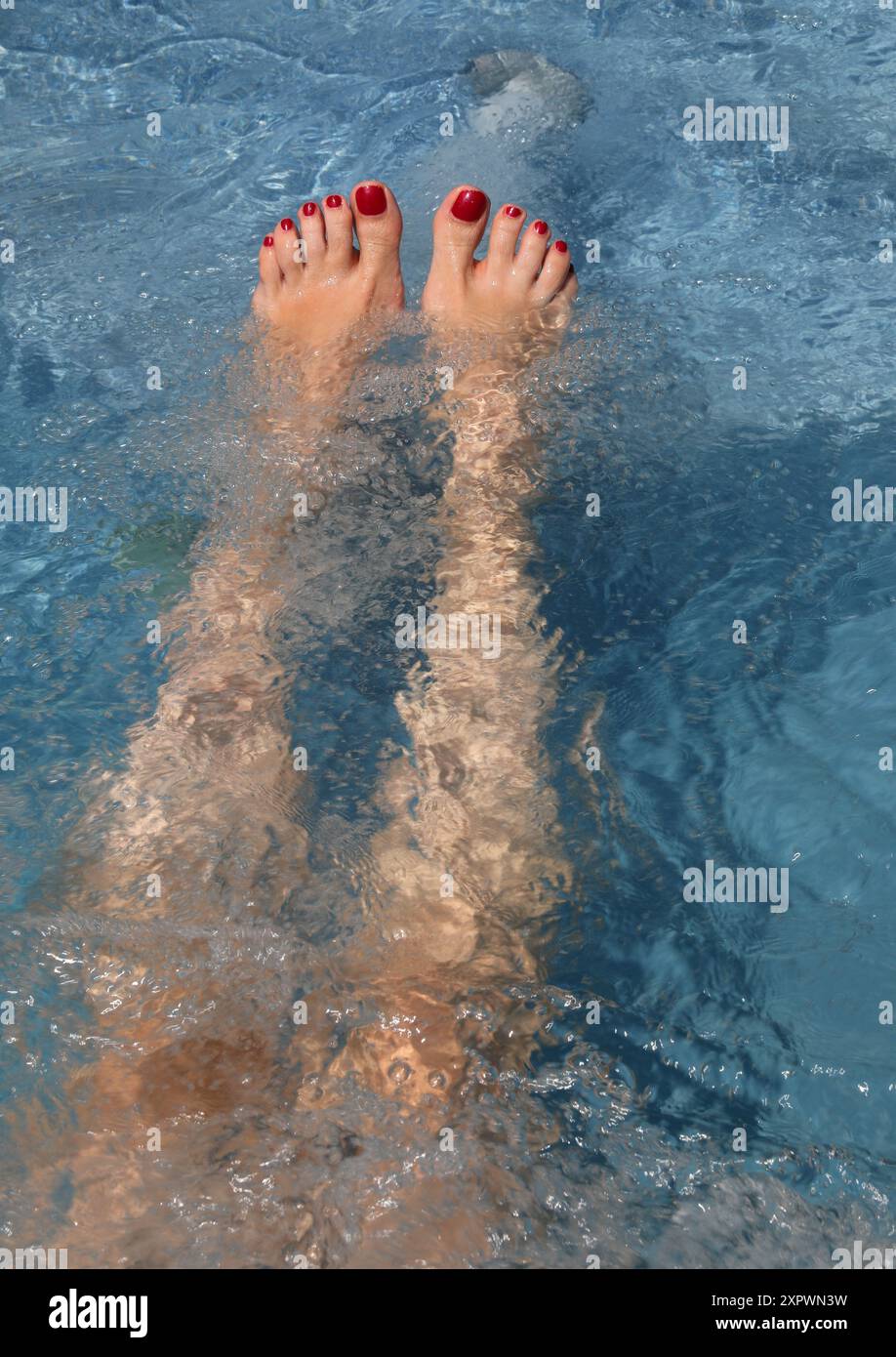 long tapered legs and beautifully painted toenails of a woman as she ...