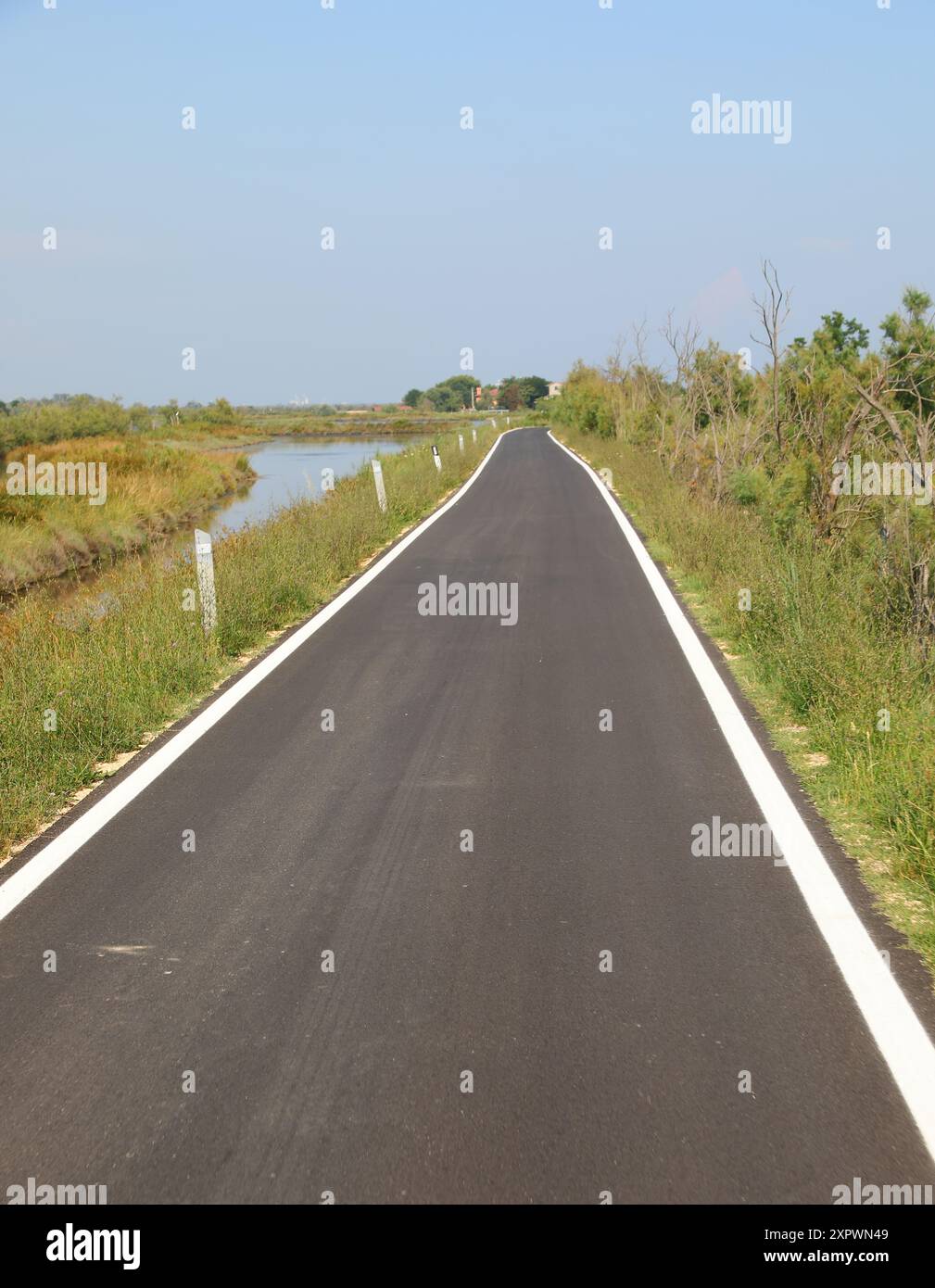 long straight stretch of a newly asphalted road leading towards ...