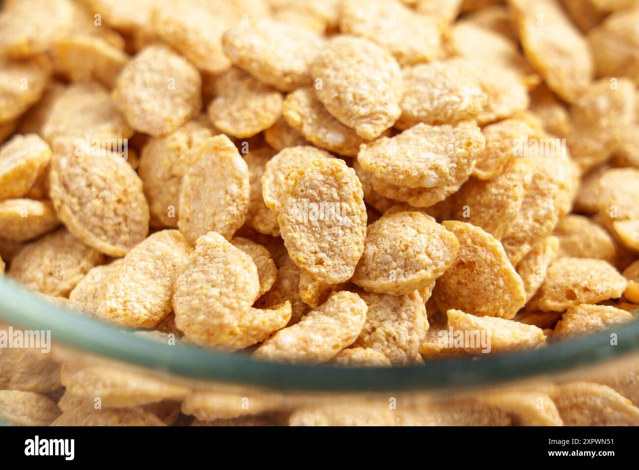 Crispy breakfast cereal flakes in the form of grains in a glass ...