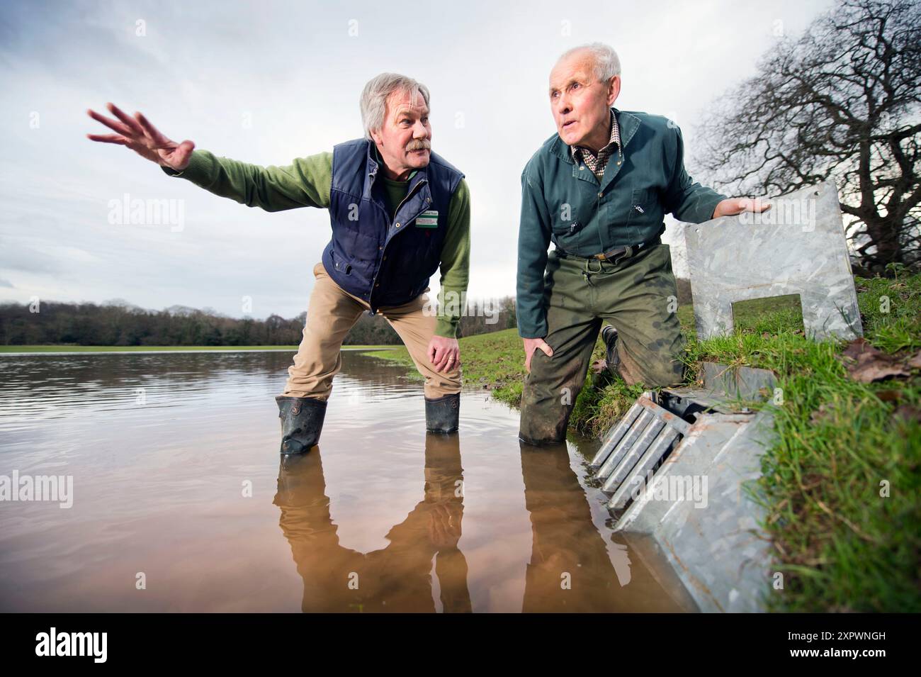 A farmer and National Trust manager check the drainage outlet on the ...