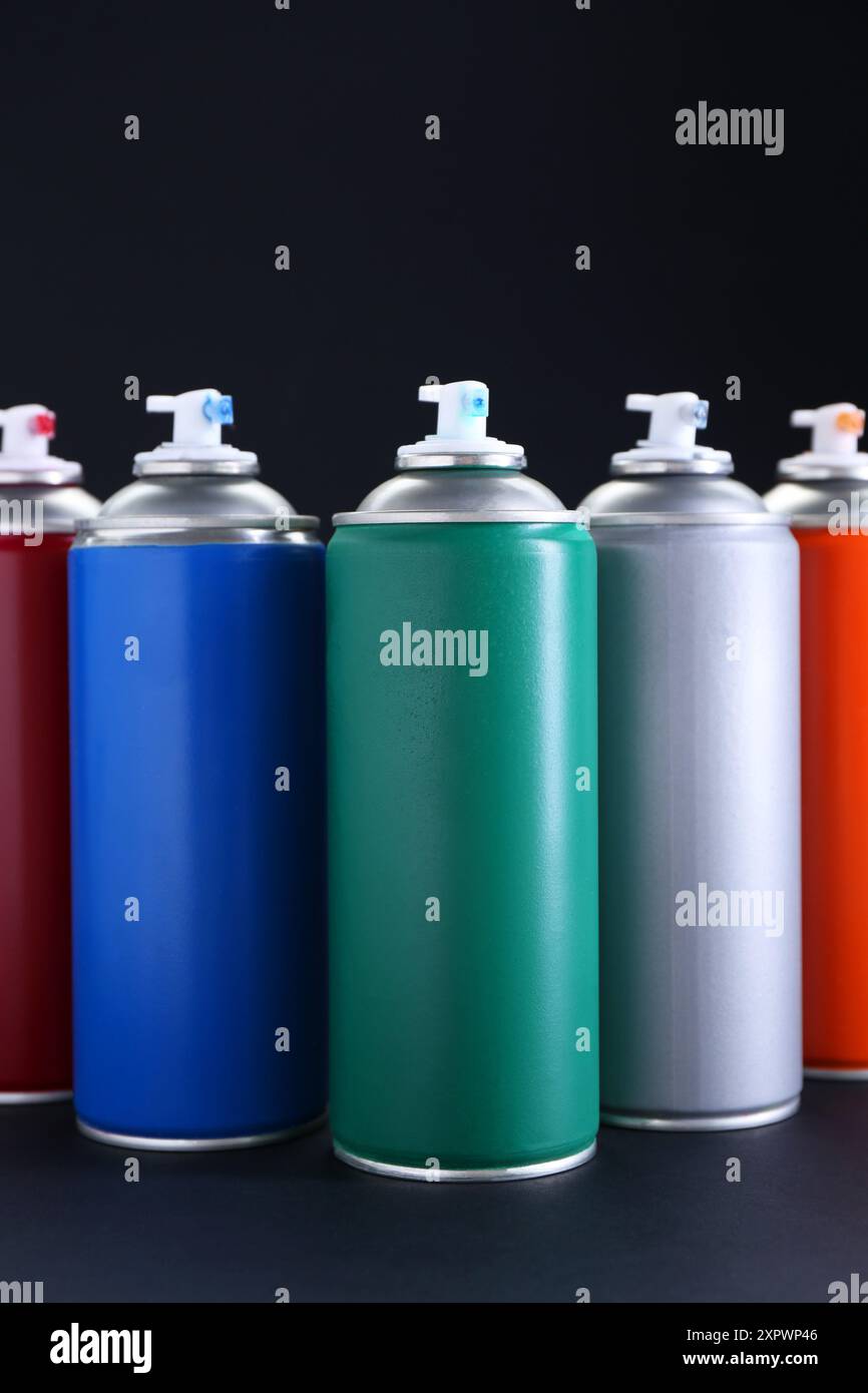 Many spray paint cans on dark gray background Stock Photo - Alamy
