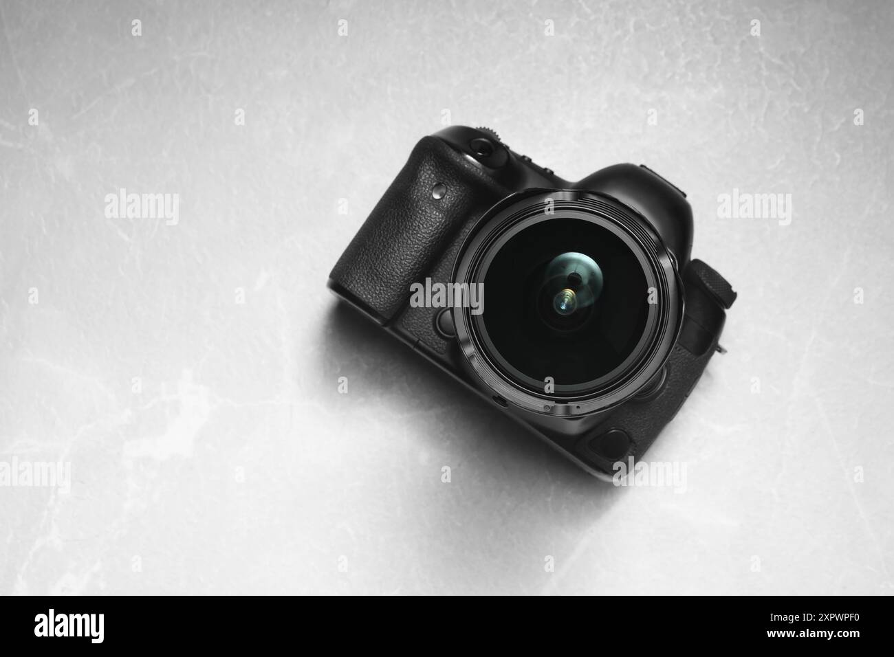 Modern photo camera on light grey marble table, top view. Space for ...