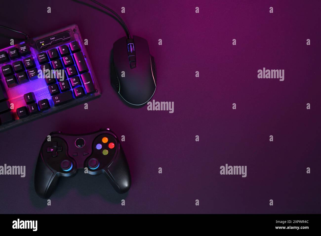 Computer mouse, RGB keyboard and game controller in neon lights on dark ...