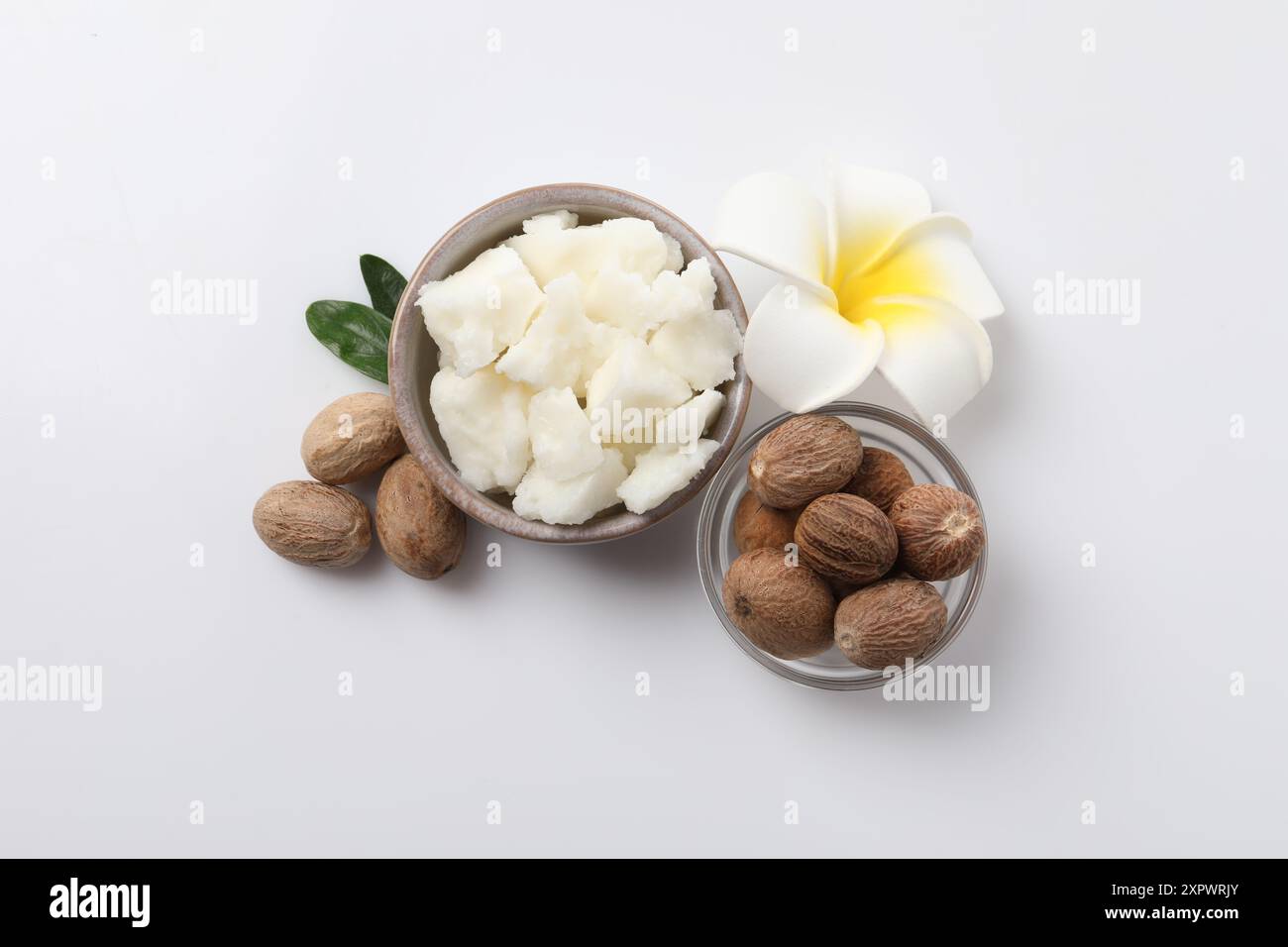 Shea butter in bowl, flower and nuts isolated on white, top view Stock ...