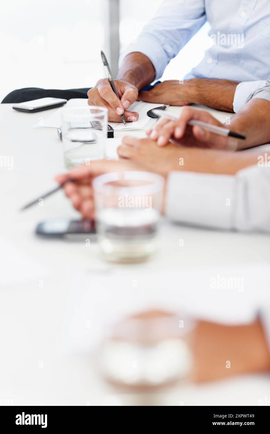Hands, meeting and writing with business people at table in boardroom ...