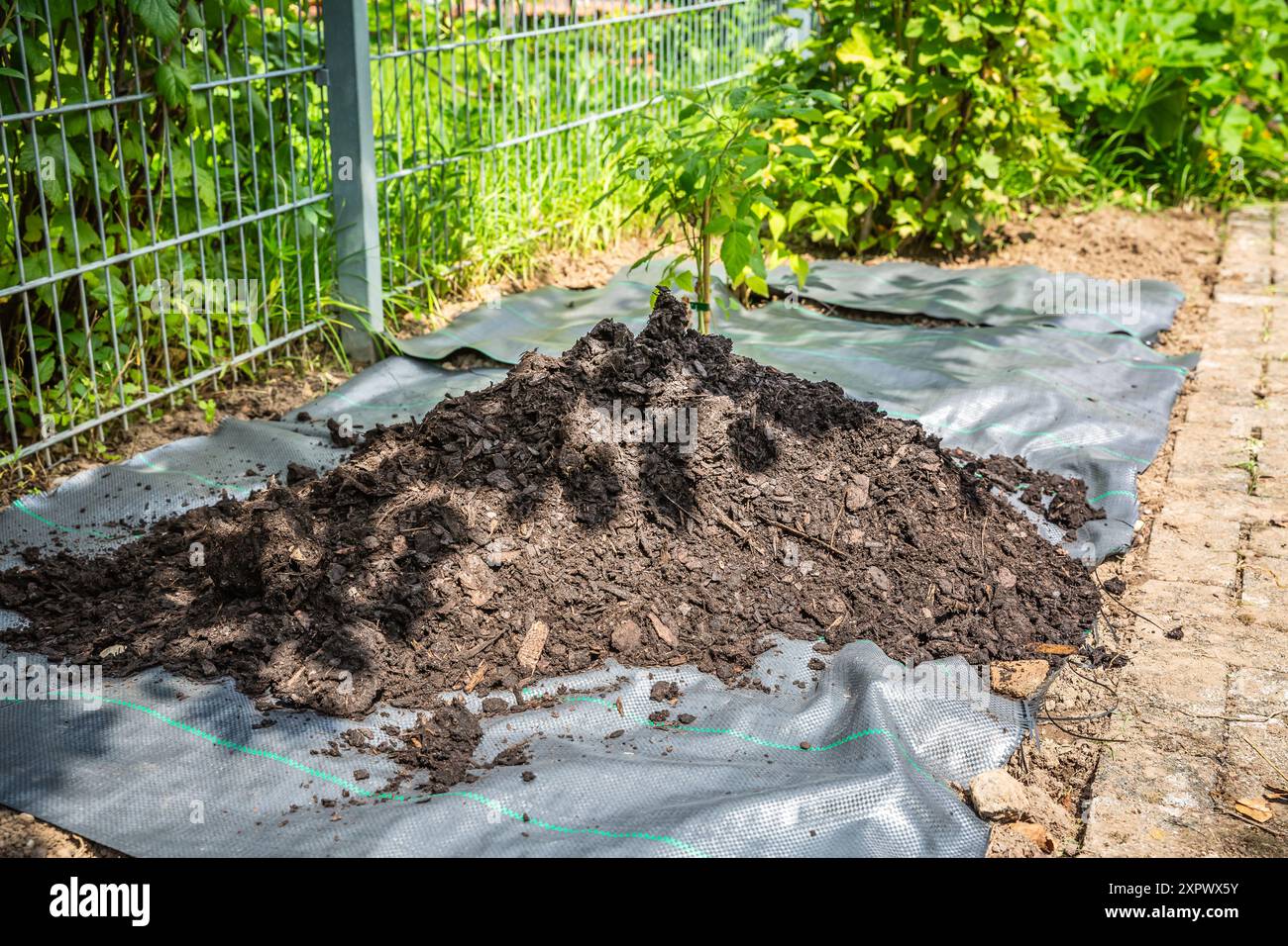 Installing weed control fabric material and bark mulch in a residential ...