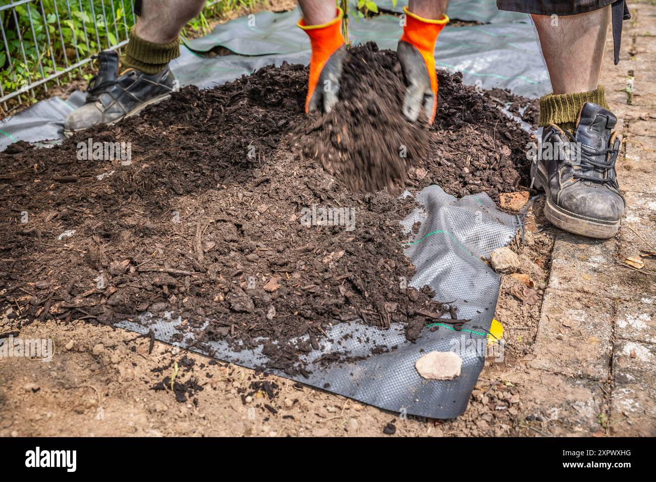 Installing weed control fabric material and bark mulch in a residential ...