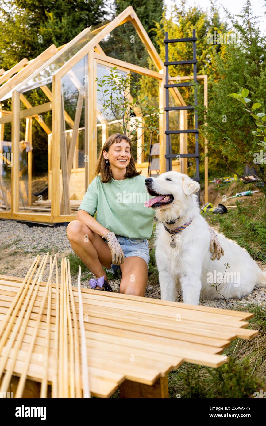 Female carpenter with her dog building wooden greenhouse Stock Photo ...