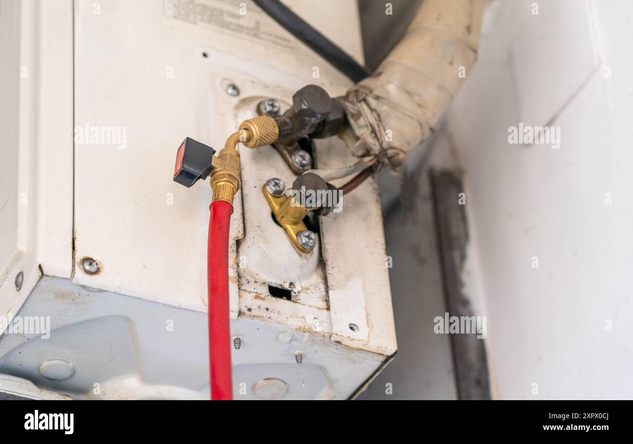 Air conditioner outdoor unit connections with red hose attached for ...