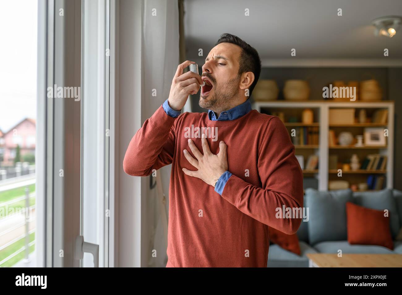 Suffocated young man suffering chest pain inhaling through asthma pump ...